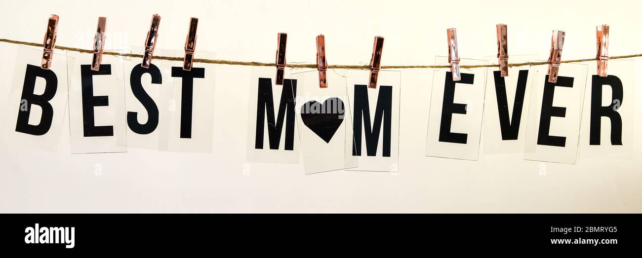 BEST MOM EVER text on white table background and clothespins on rope ...