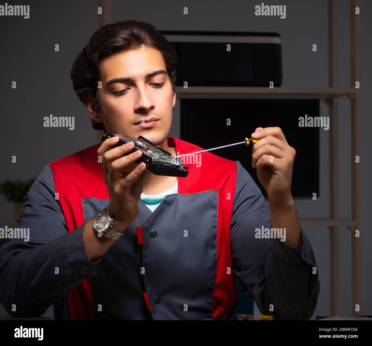 The young handsome repairman repairing computer Stock Photo - Alamy