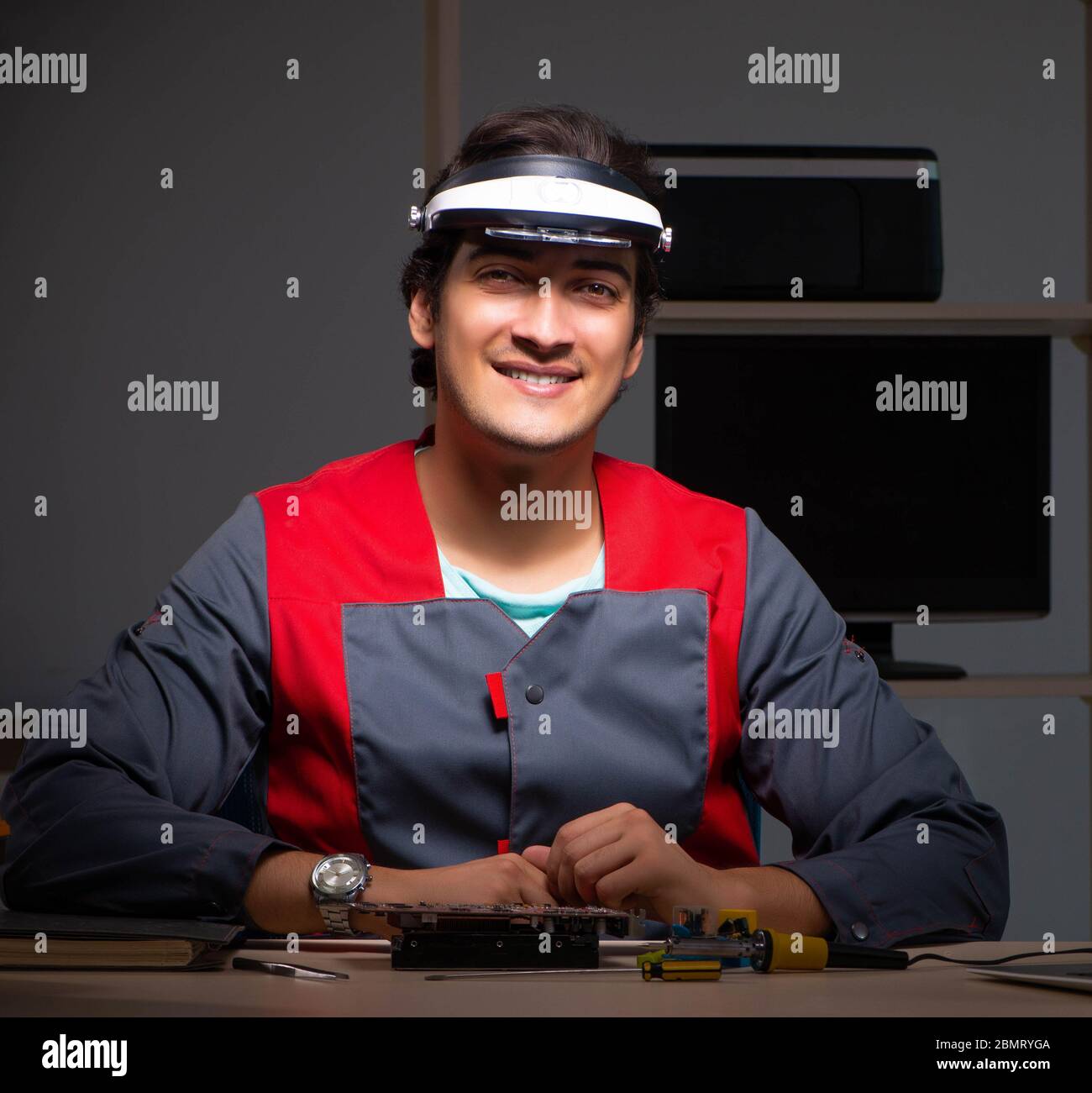The young handsome repairman repairing computer Stock Photo - Alamy