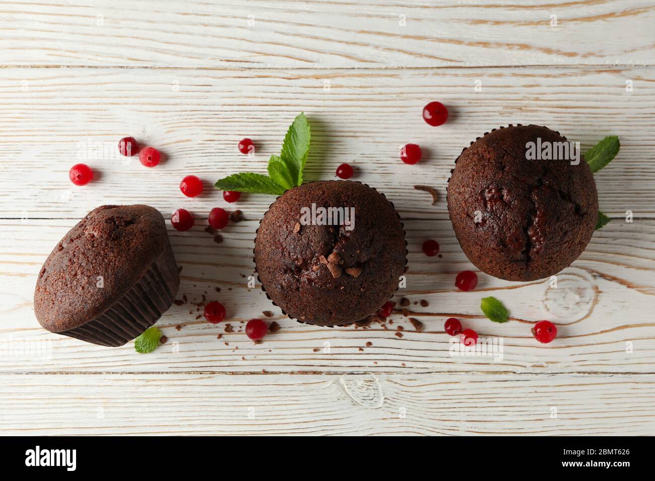 Composition with chocolate muffins and berries on white wooden ...