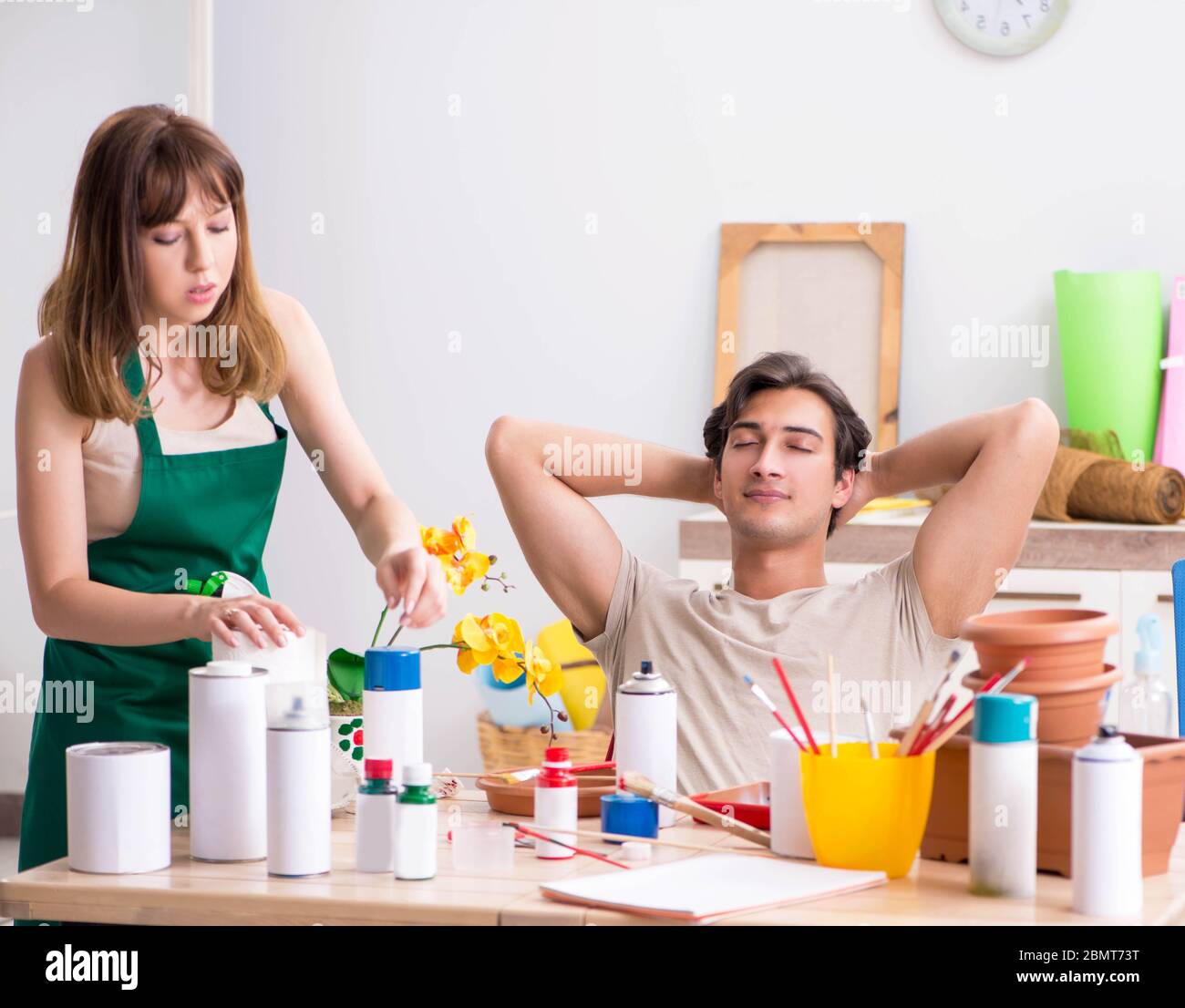 The couple decorating pots in workshop during class Stock Photo - Alamy