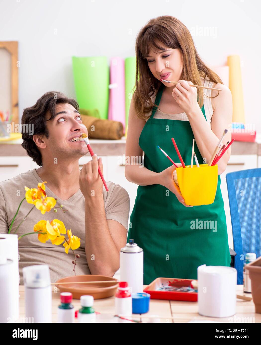 The couple decorating pots in workshop during class Stock Photo - Alamy