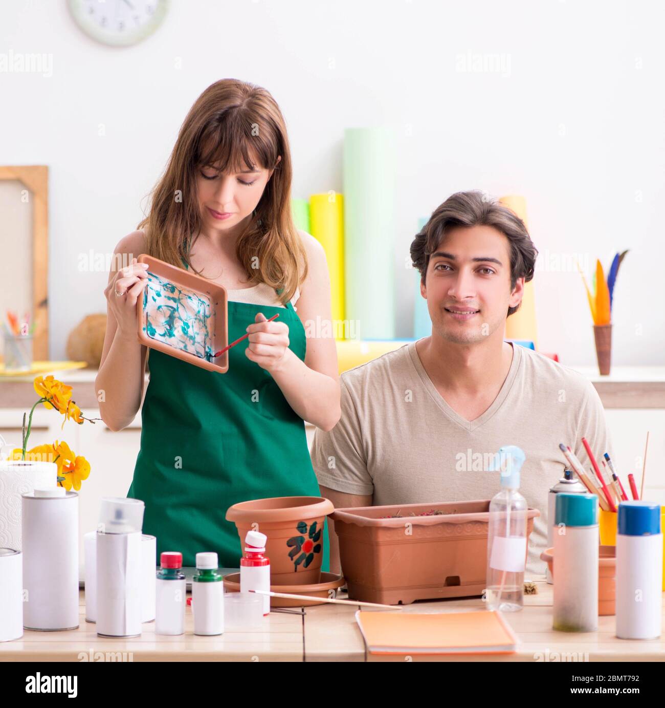 The couple decorating pots in workshop during class Stock Photo - Alamy