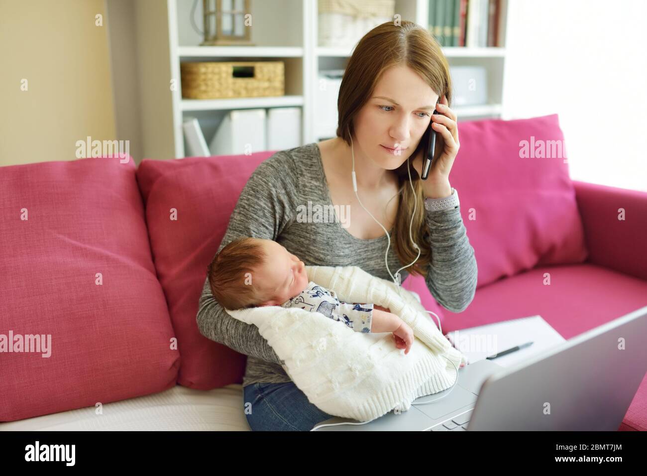 Young mom works remotely from home office with newborn baby. Freelancer ...