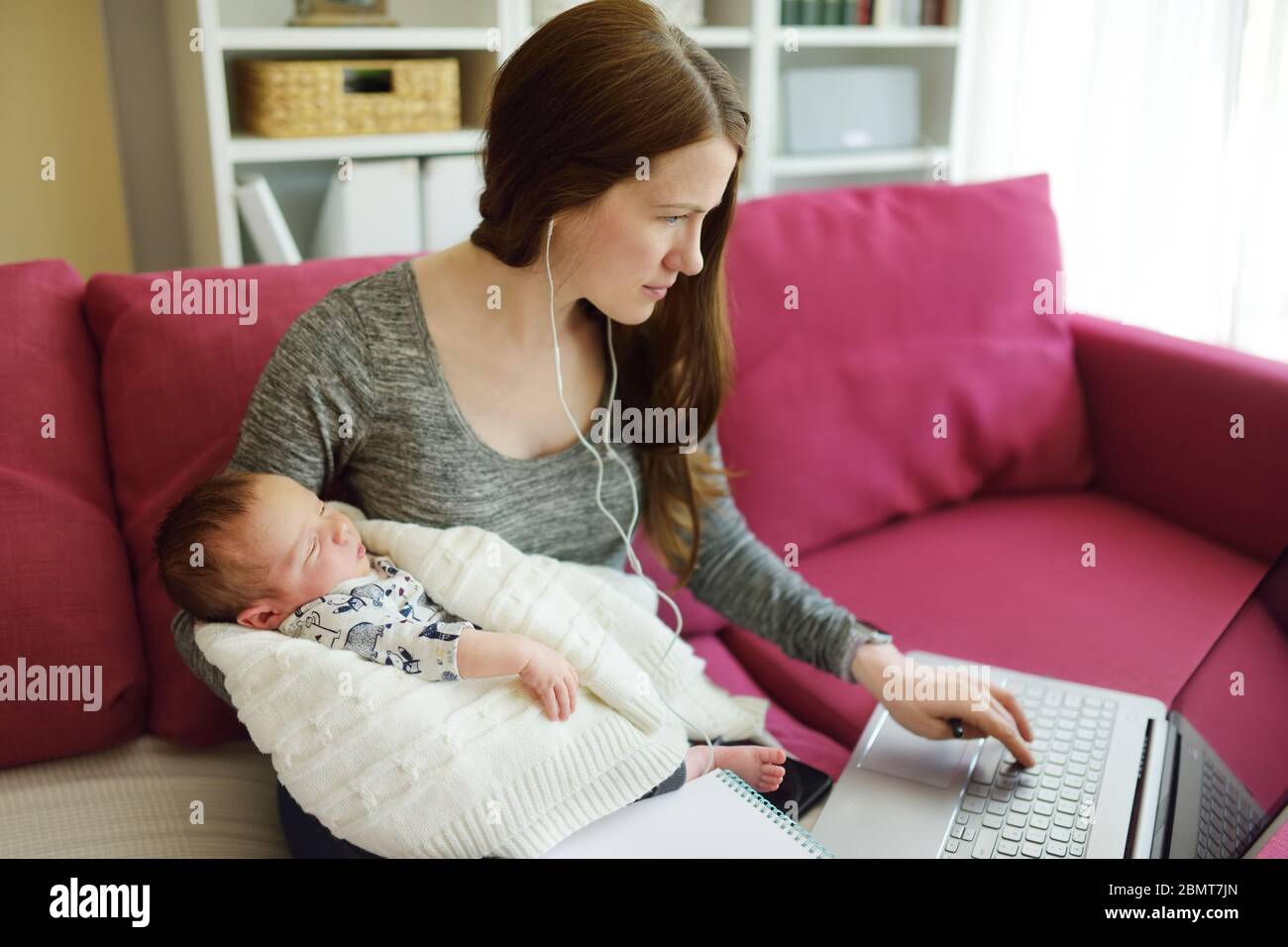 Young mom works remotely from home office with newborn baby. Freelancer ...