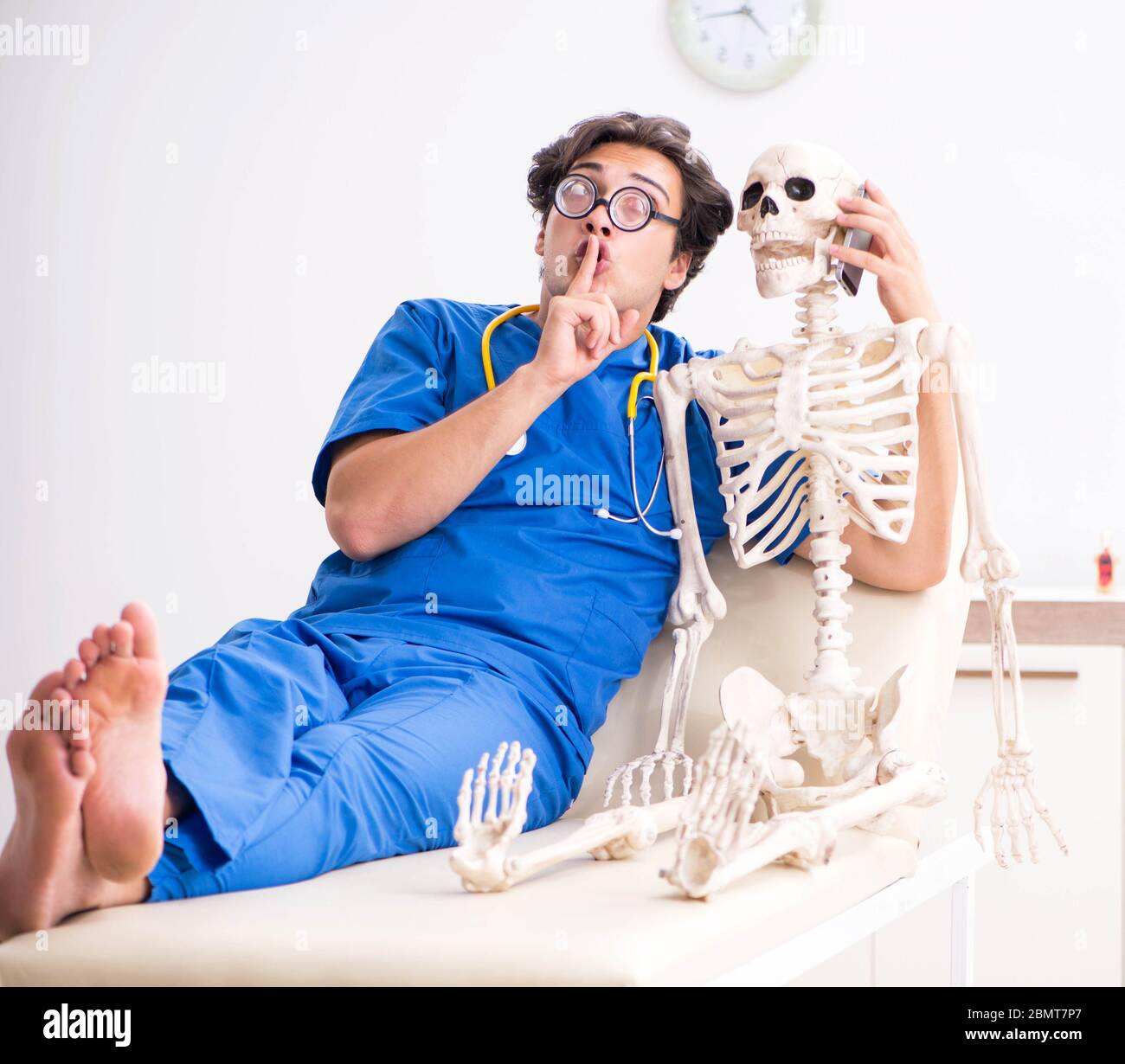 The funny doctor with skeleton in hospital Stock Photo - Alamy