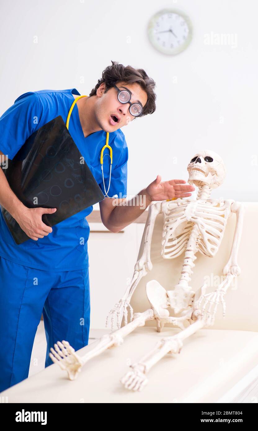 The funny doctor with skeleton in hospital Stock Photo - Alamy
