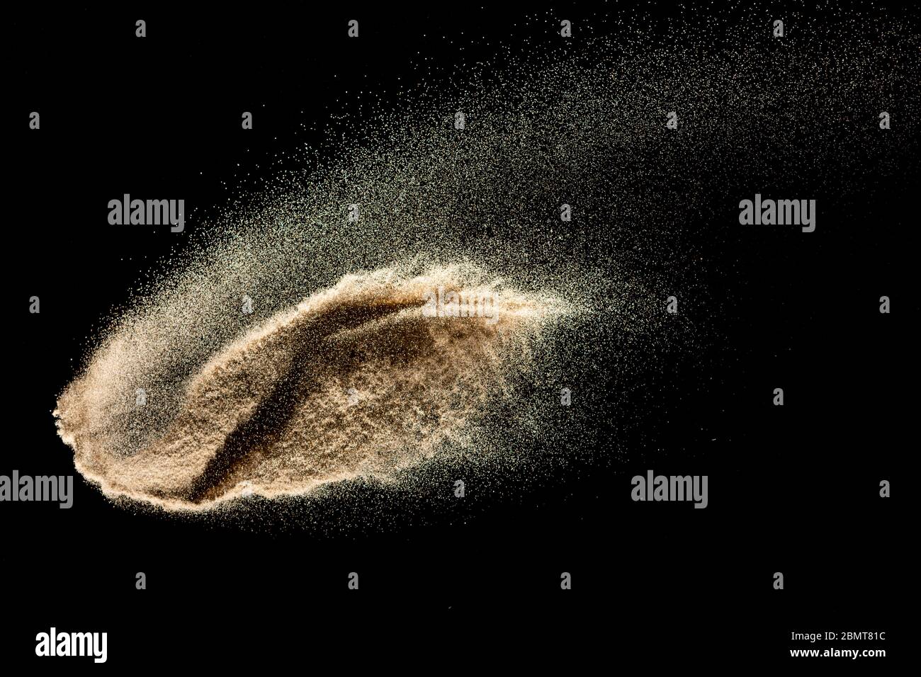 Brown sand explosion isolated on black background. Freeze motion of ...