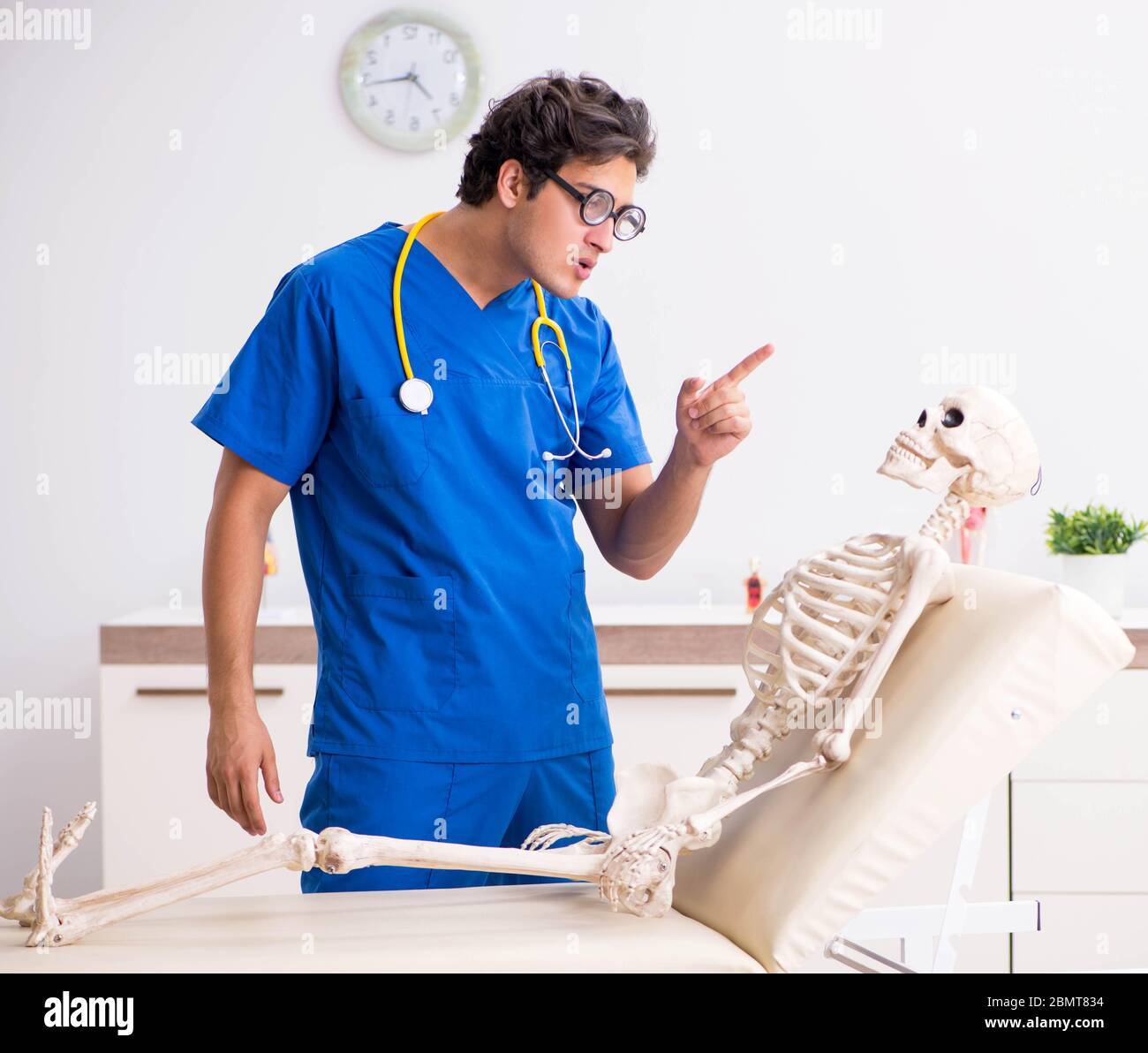 The funny doctor with skeleton in hospital Stock Photo - Alamy