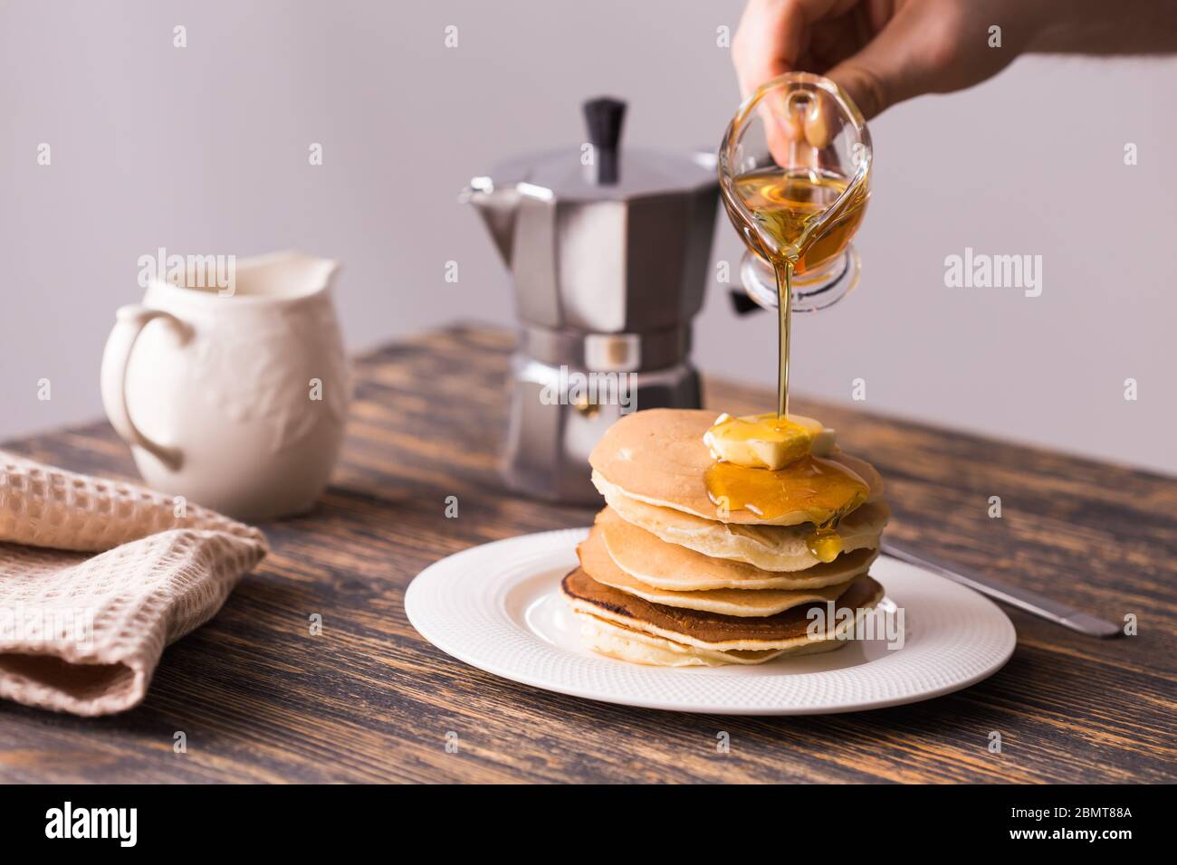 Maple syrup pouring over a stack of mini pancakes Stock Photo - Alamy
