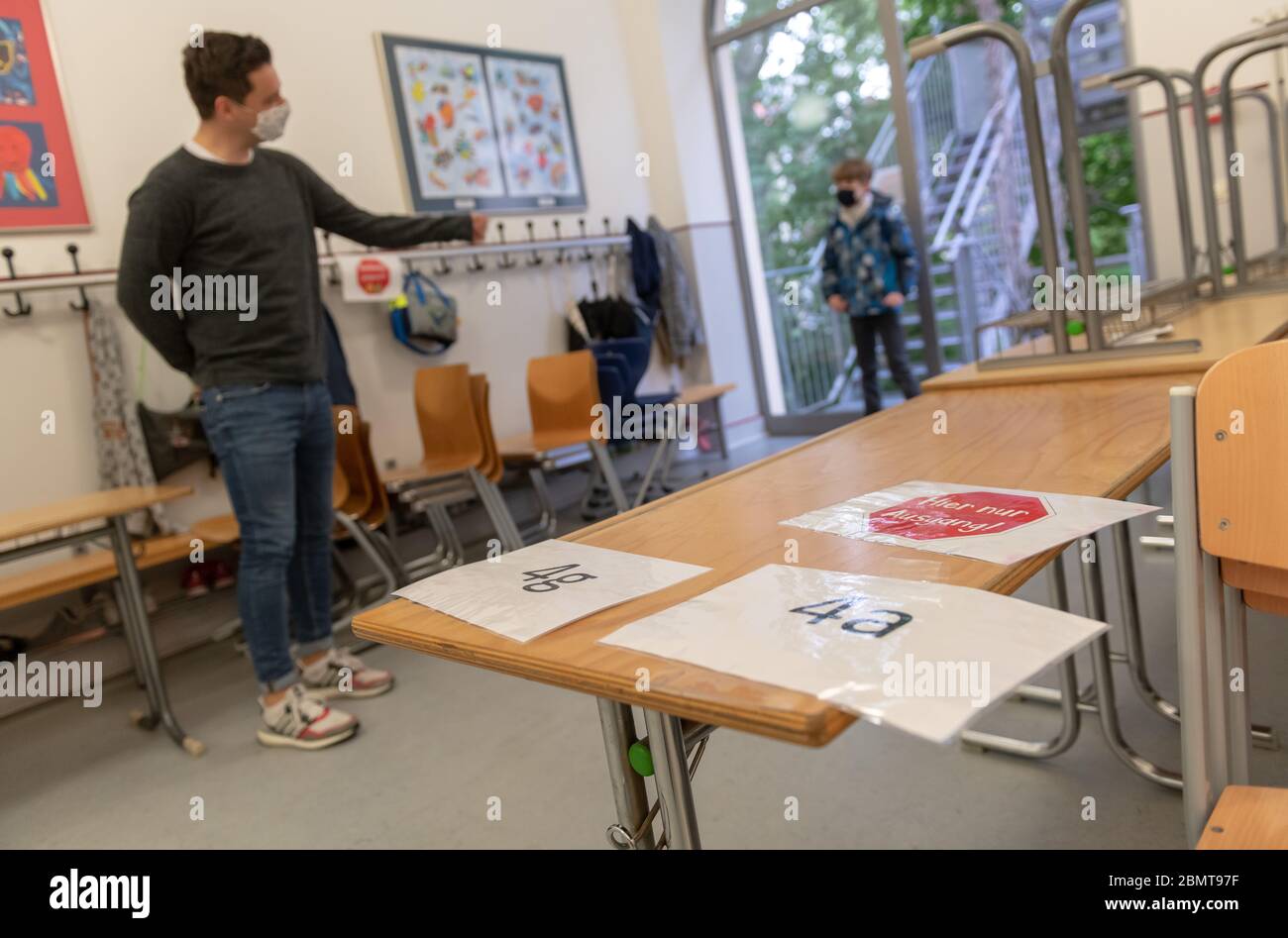 Munich, Germany. 11th May, 2020. A teacher with a mouthguard waves to a ...