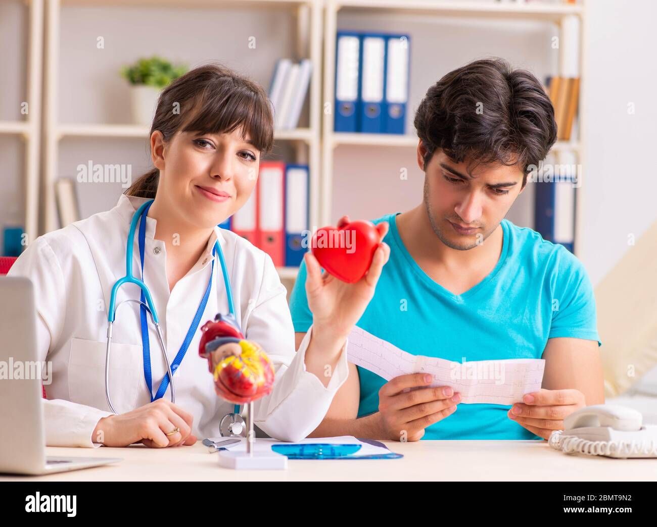 The young man visiting female doctor cardiologist Stock Photo - Alamy