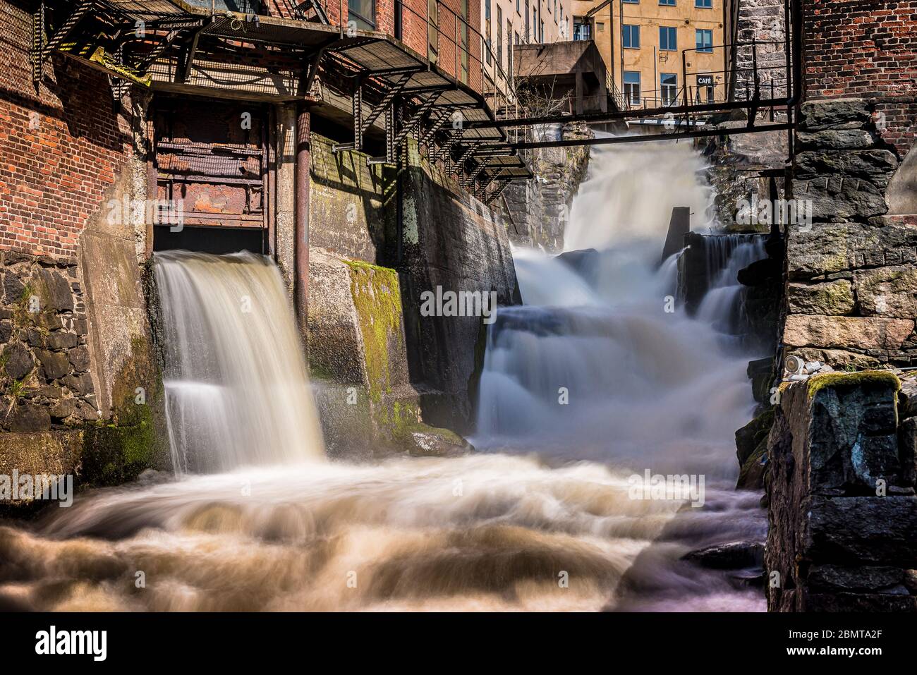 Waterfall running through buildings. Long esposure Stock Photo - Alamy