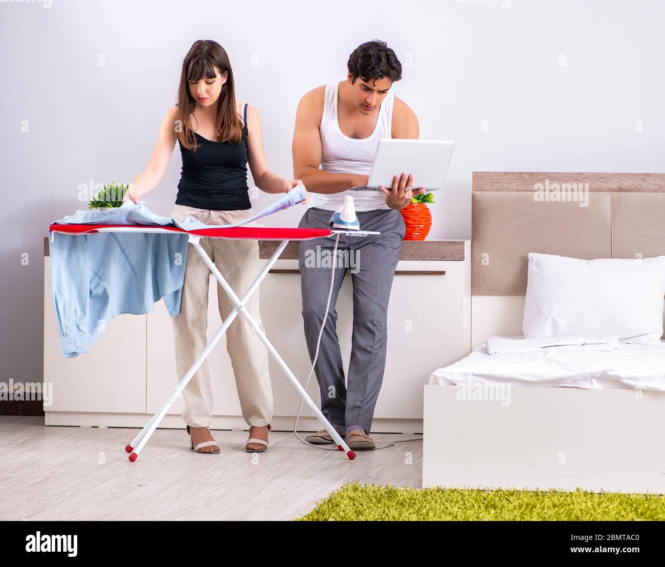 The young woman doing ironing for her husband Stock Photo - Alamy