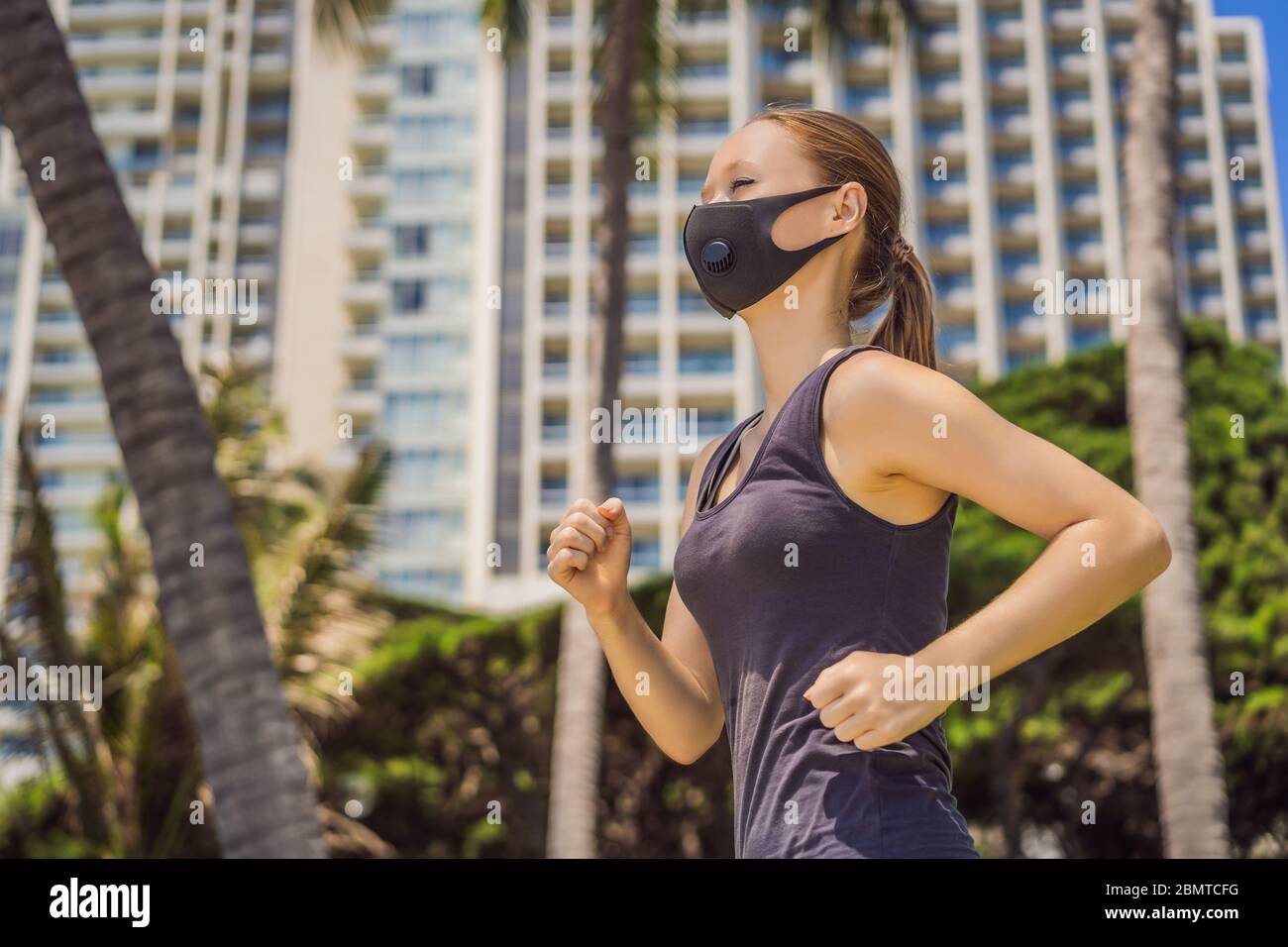 Woman runner wearing medical mask. Running in the city against the ...