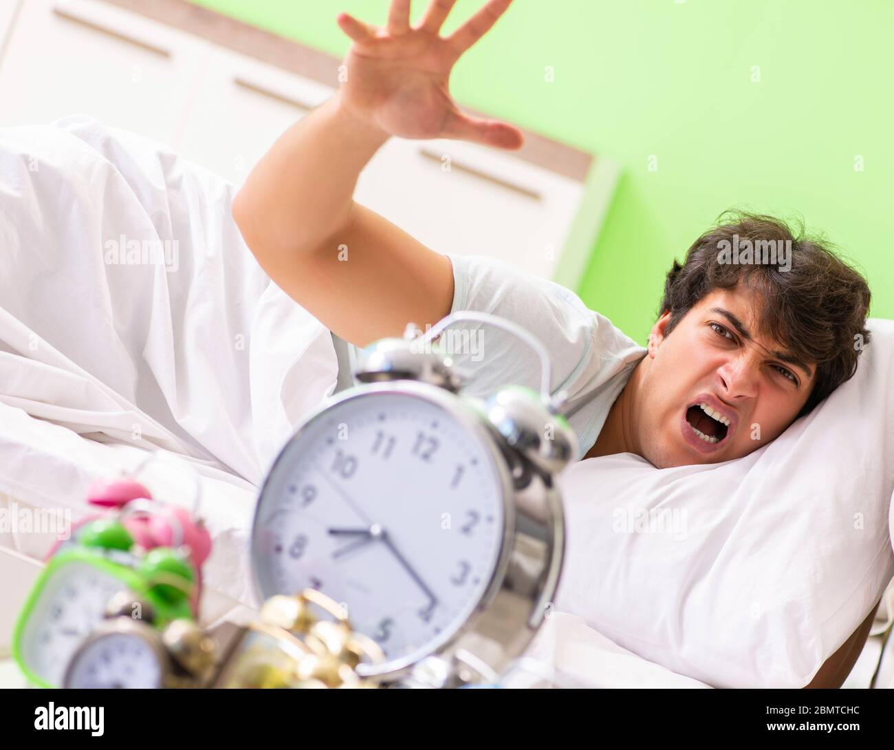 The young man having trouble waking up in early morning Stock Photo - Alamy