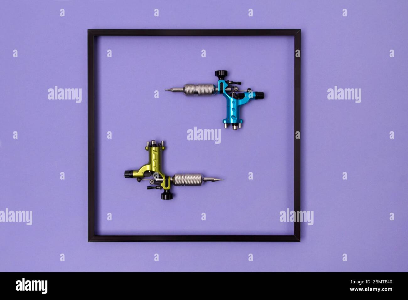 Tattoo machines in frame on purple background. Mock up for tattooing ...