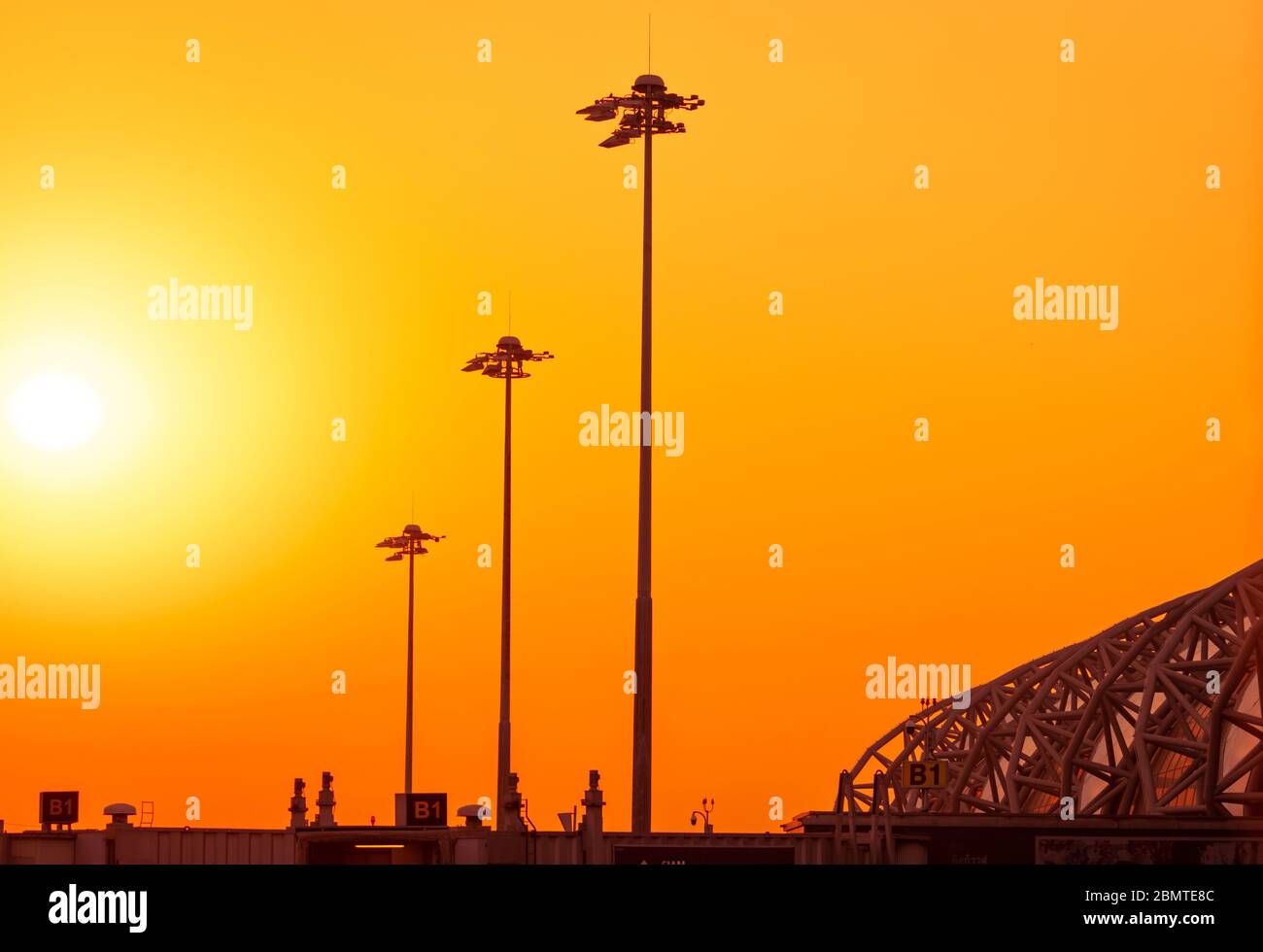 Tall electric pylon in the airport at sunset with an orange sky ...