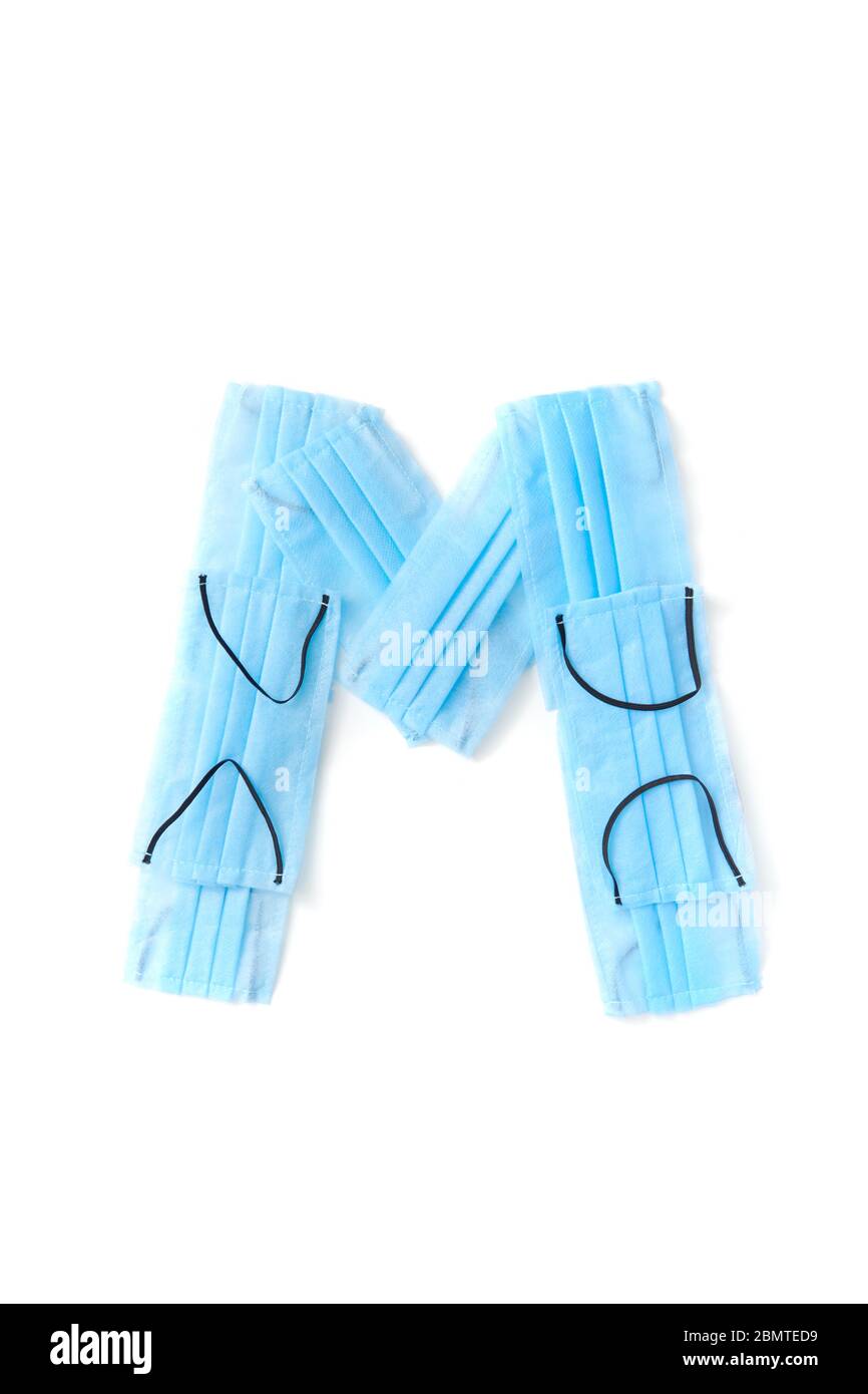 Letter M made from protective medical masks on a white background Stock ...