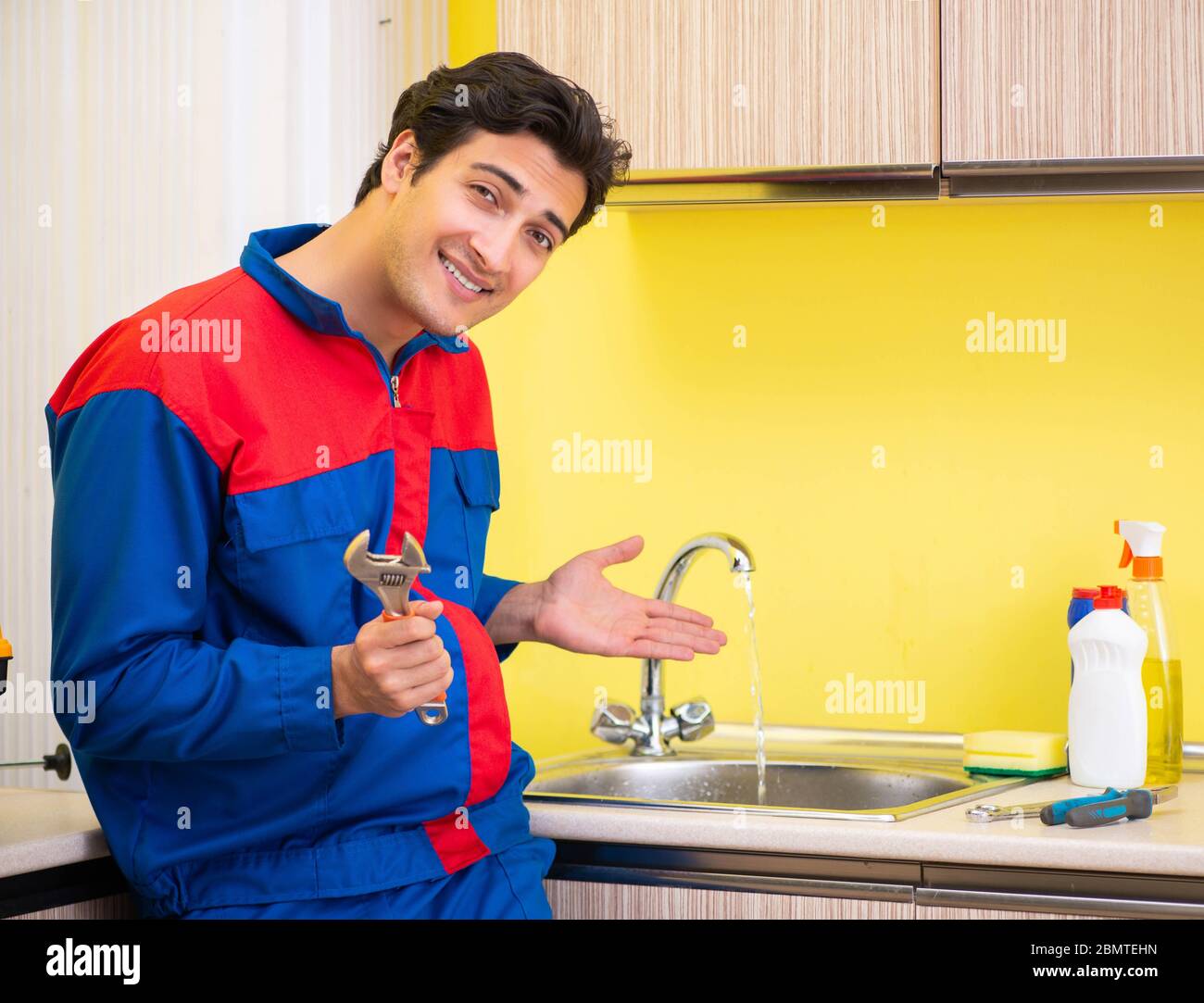 The plumber repairing tap at kitchen Stock Photo - Alamy