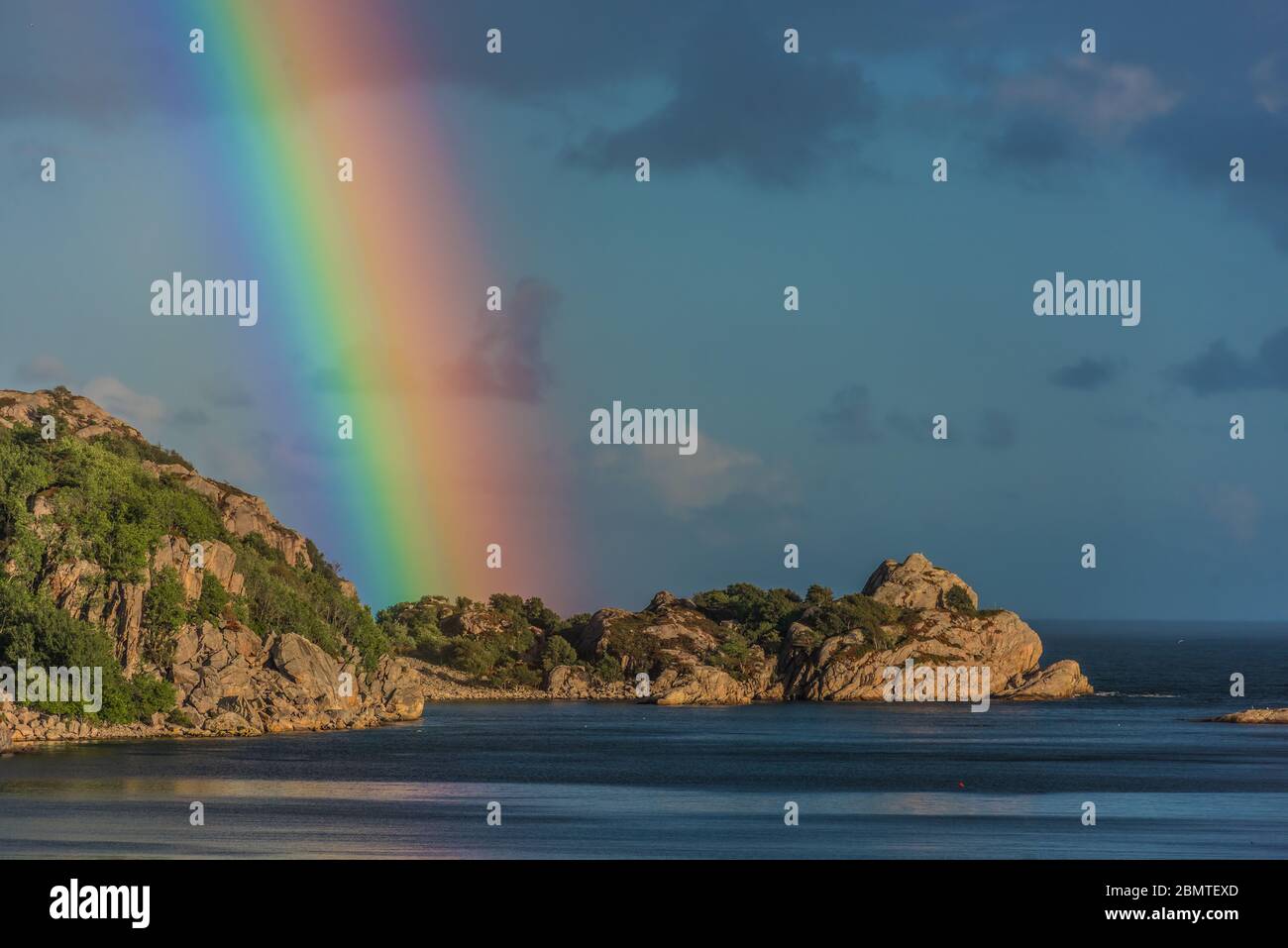 Intense rainbow rising above cliffs Stock Photo - Alamy