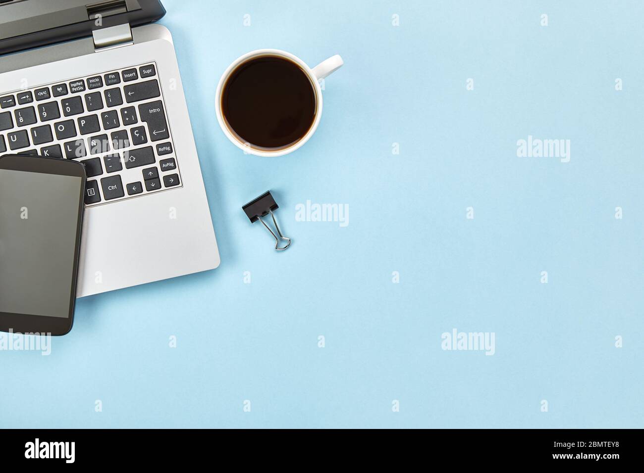 Flat lay image of blue workspace with laptop, smartphone, coffee and ...