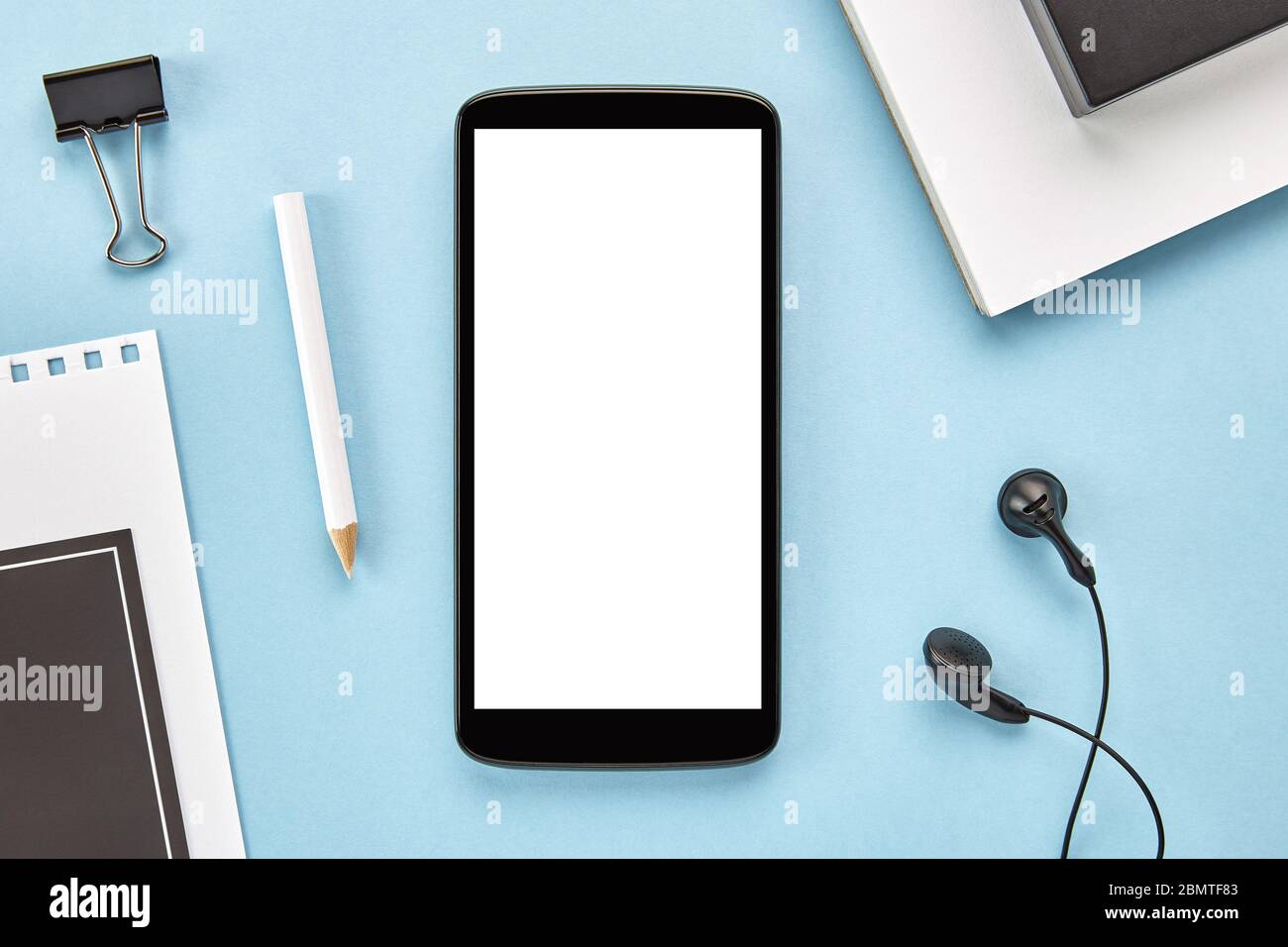 Mockup image of a smartphone with blank white screen on blue surface ...