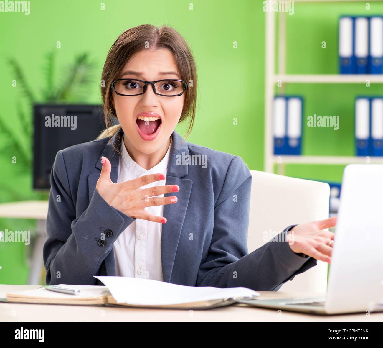 The young female employee very busy with ongoing paperwork Stock Photo ...