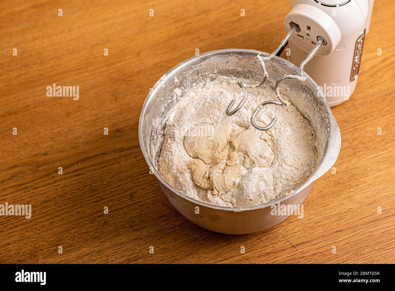 Hand mixer and a metal bowl with dough Stock Photo - Alamy