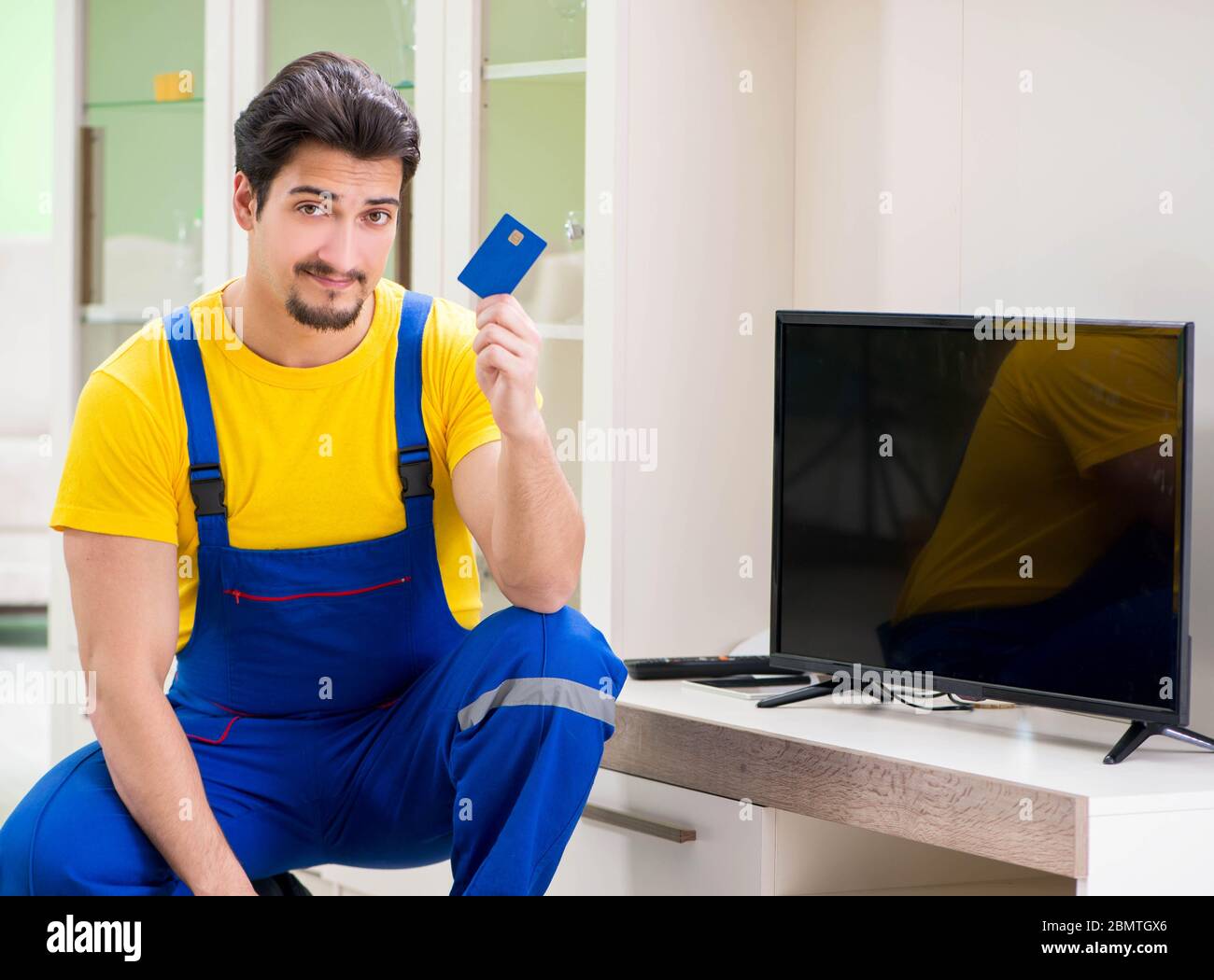 The male professional serviceman repairing tv at home Stock Photo - Alamy