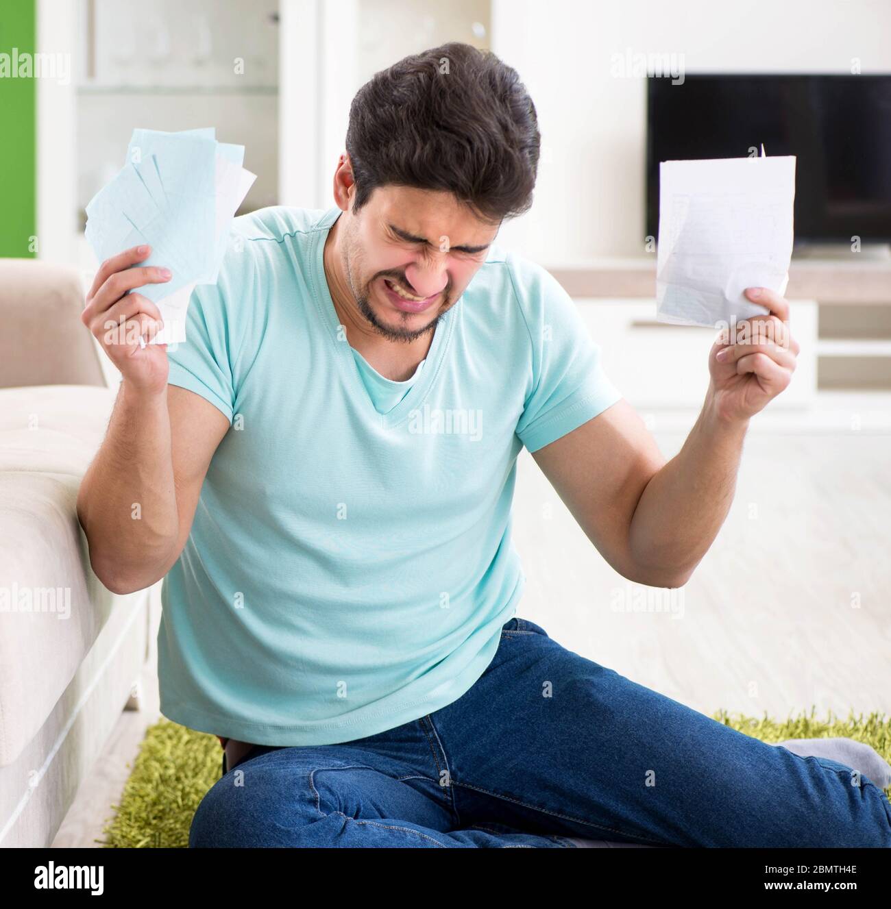 The young man struggling with personal finance and bills Stock Photo ...