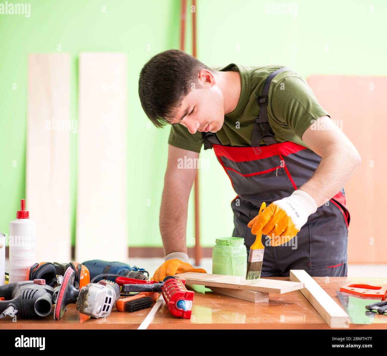 The young man carpenter working in workshop Stock Photo - Alamy