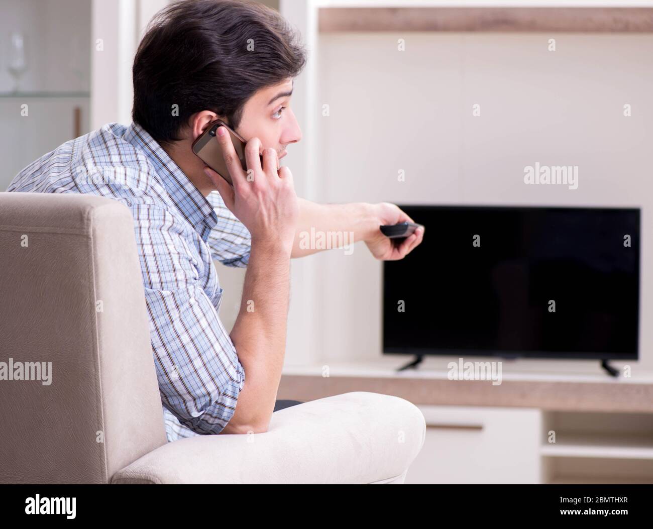 The young man watching tv at home Stock Photo - Alamy