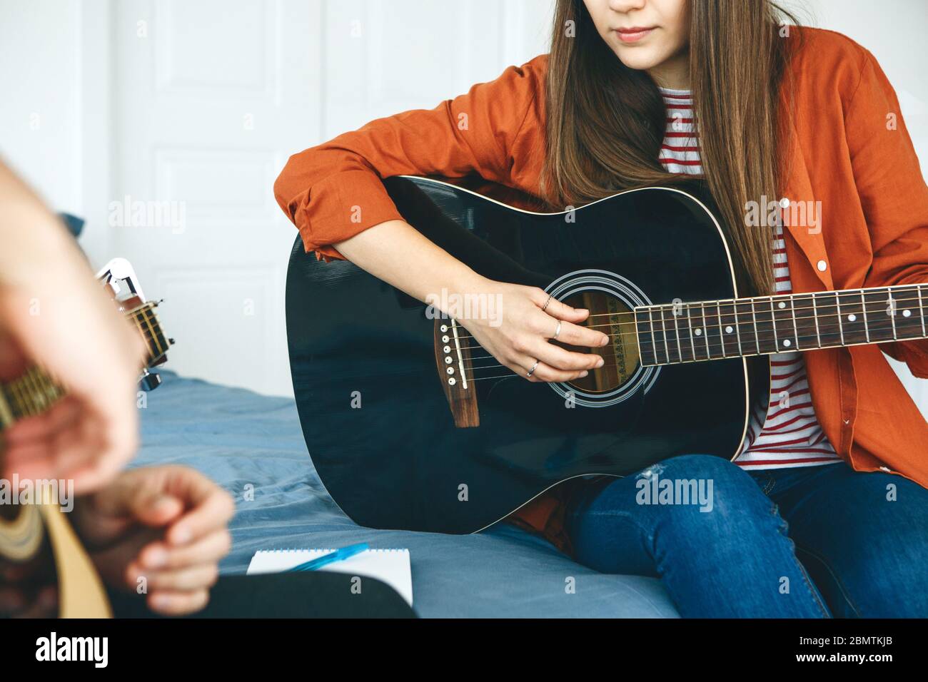Learning to play the guitar. The teacher explains to the student the ...