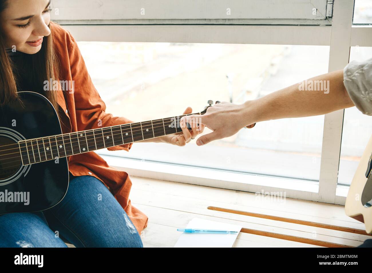 Learning to play the guitar. The teacher explains to the student the ...