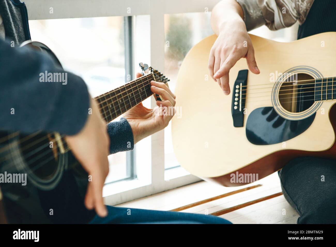 Learning to play the guitar. The teacher explains to the student the ...