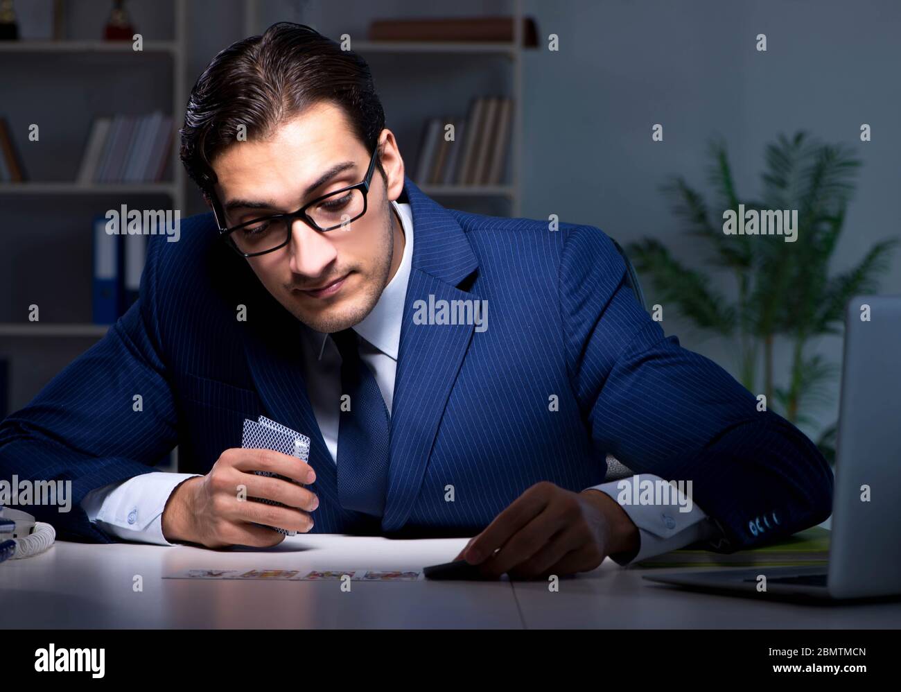 The young business playing cards late in office Stock Photo - Alamy