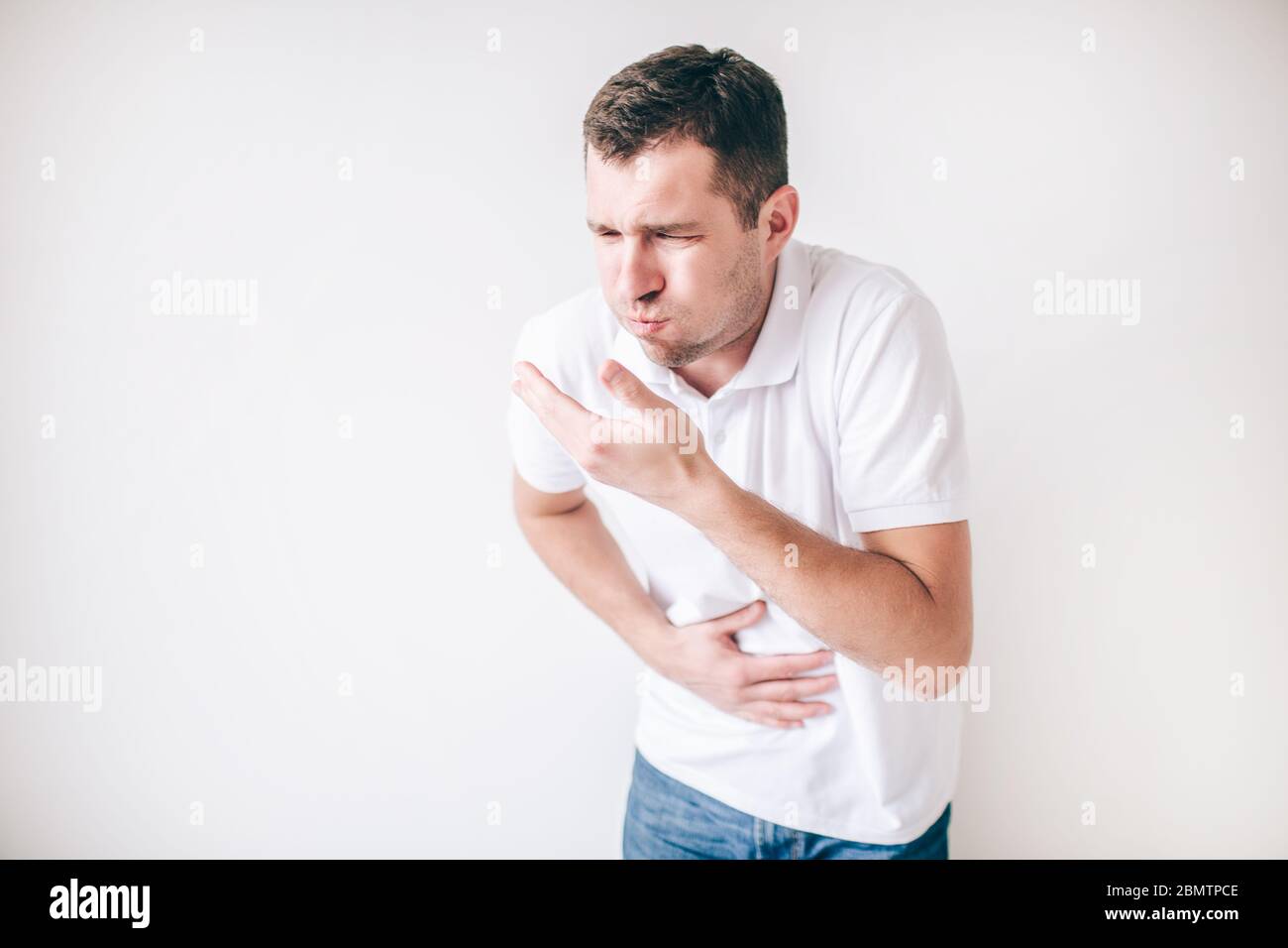Young sick man isolated over white background. Almost vomiting into ...