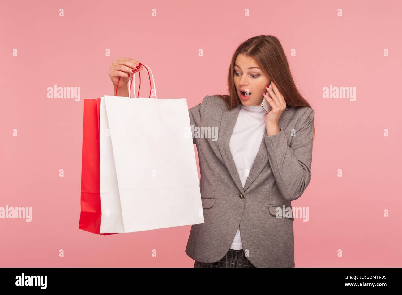 Portrait of amazed shopper, business client, elegant woman in suit ...