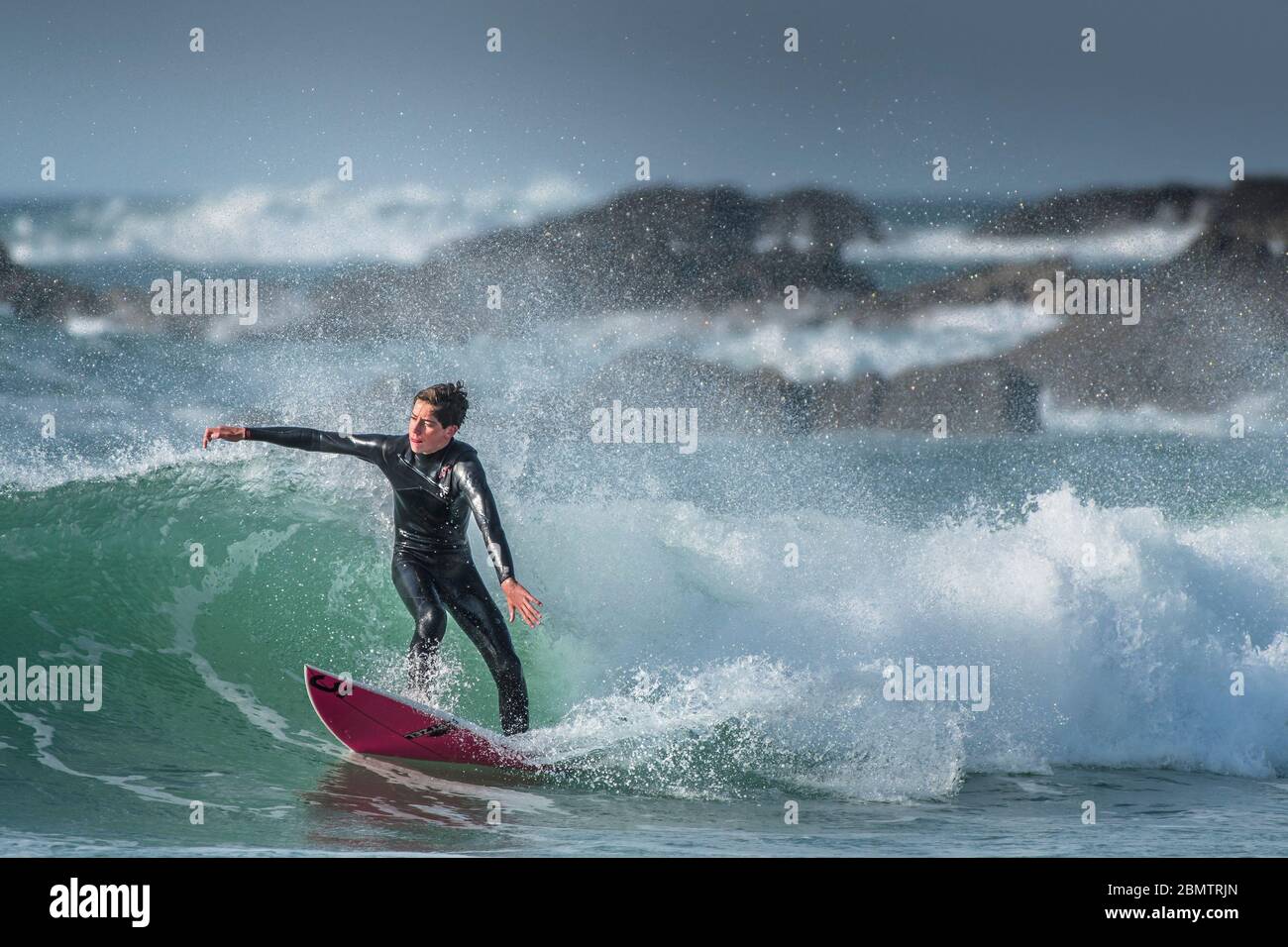 Spectacular surfing action as a young male surfer rides a wave at ...