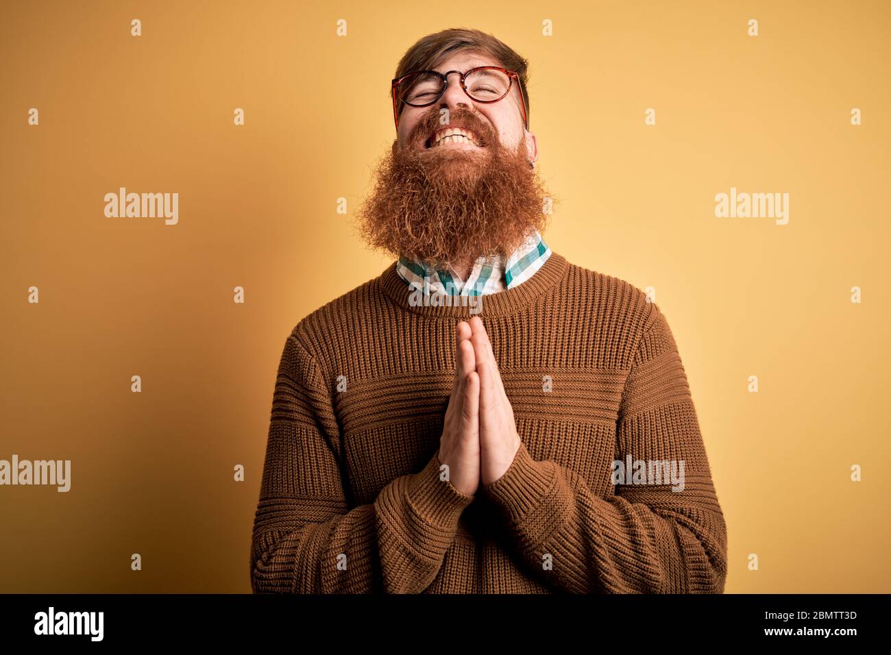Handsome Irish redhead man with beard wearing glasses and winter ...