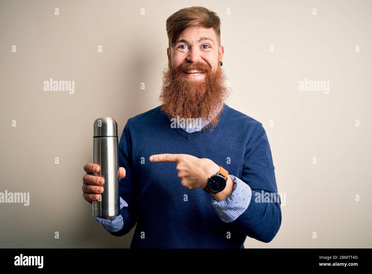 Redhead Irish man with beard holding takeaway beverage thermo over ...
