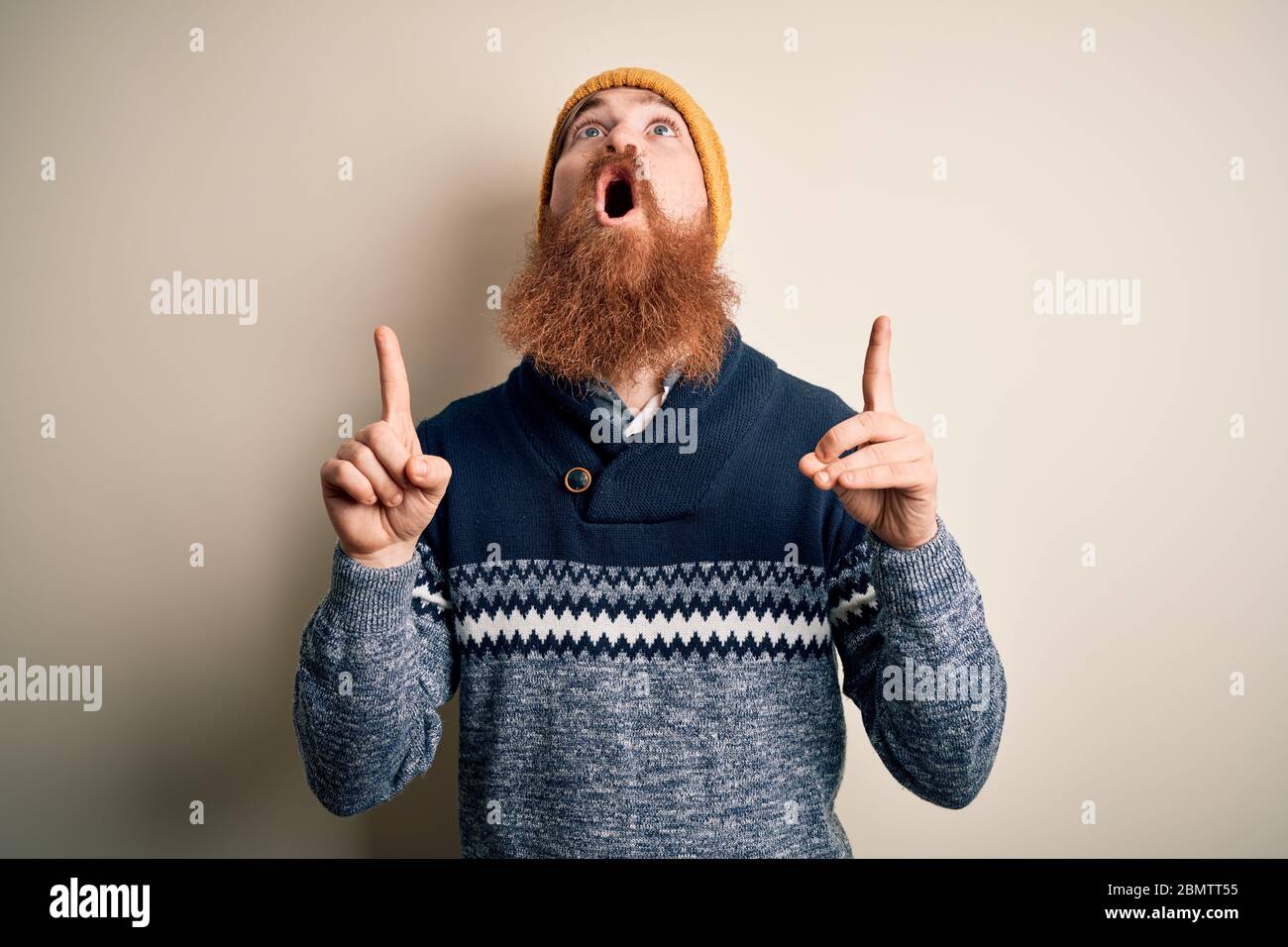 Handsome Irish redhead man with beard wearing winter sweater and wool ...