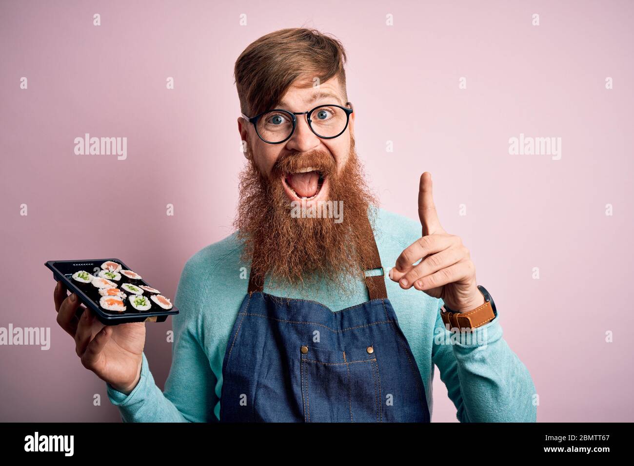 Redhead Irish cook man with beard holding maki sushi tray over isolated ...