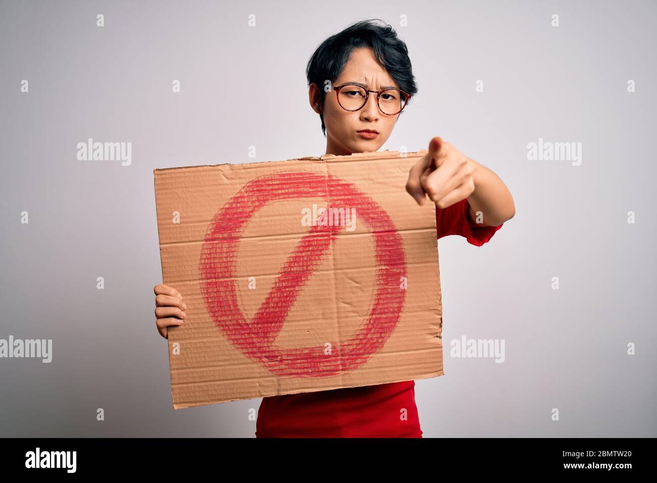 Young beautiful asian girl holding banner with prohibited signal over ...