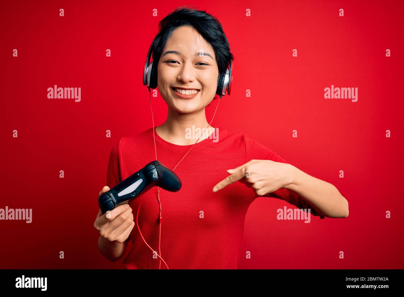 Young beautiful asian gamer girl playing video game using joystick and ...