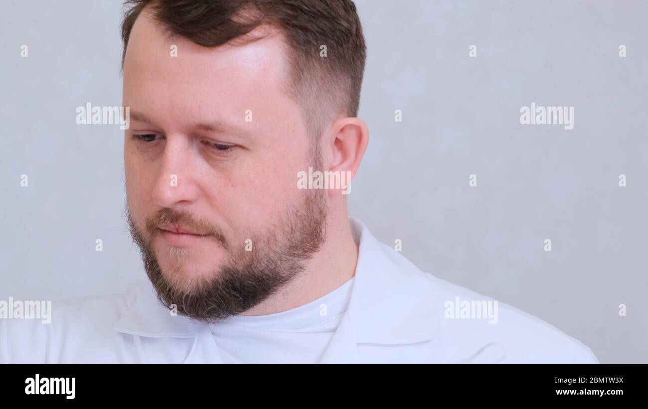 bearded man doctor lowers his head, the concept of medical treatment ...