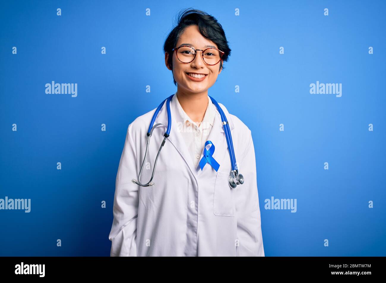 Young beautiful asian doctor girl wearing stethoscope and coat with ...