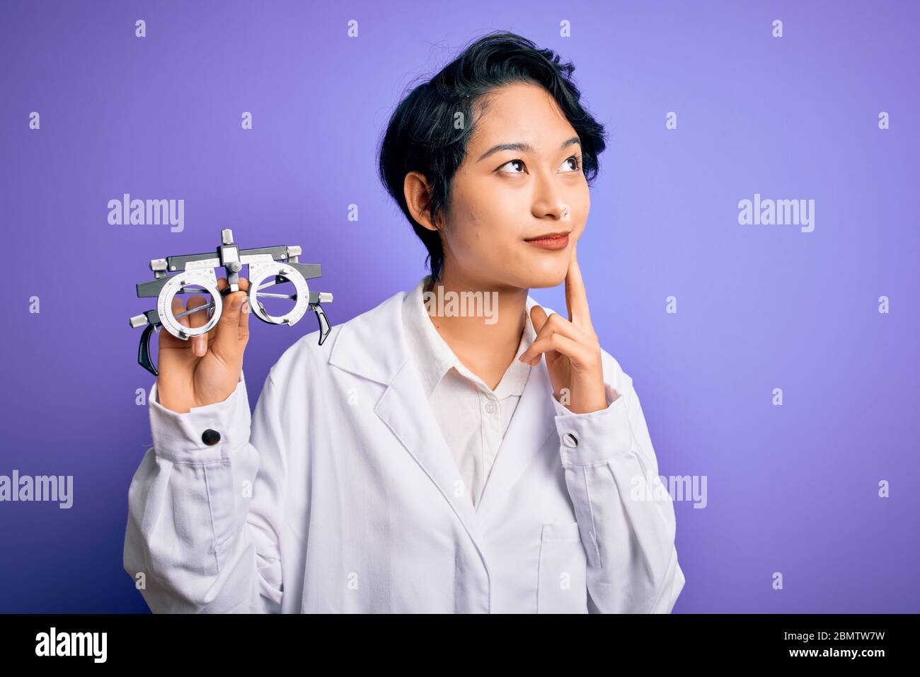 Beautiful asian optical girl wearing coat holding optometry glasses ...