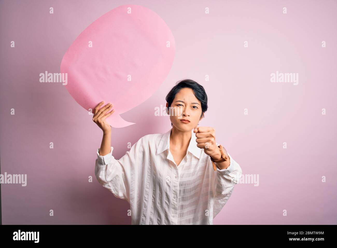 Young beautiful asian girl talking holding speech bubble over isolated ...